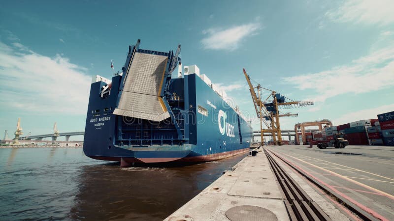Cargo Ship with Containers Sails Away from the Pier with a Crane and a ...