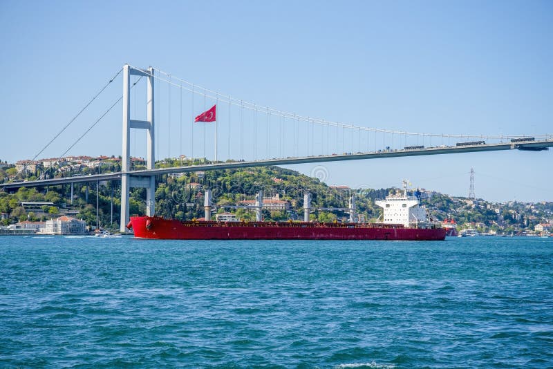 A Cargo Ship Sails Under a Bridge in Istanbul on a Summer and Sunny Day ...