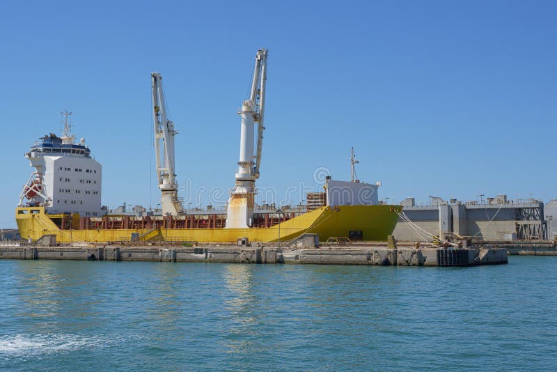 Cargo Ship Under Maintenance at a Shipyard with Two High Cranes Stock ...