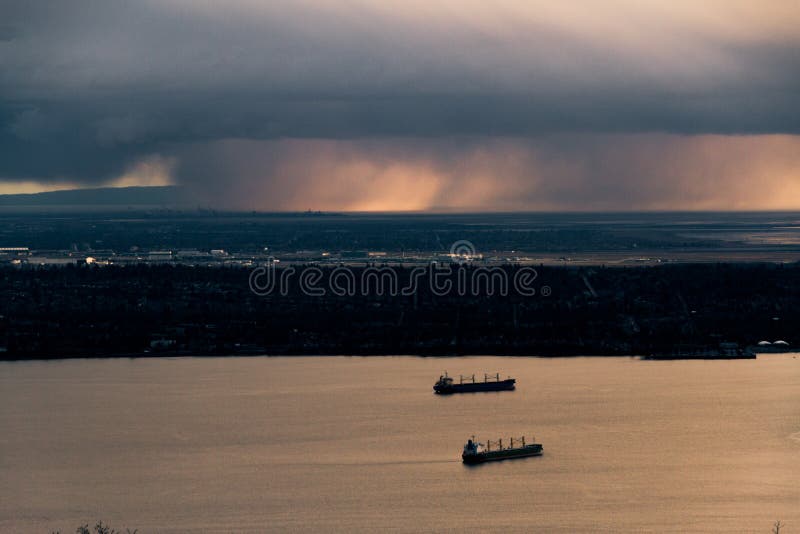 Cargo Ships on Water with Rainy Clouds in the Background Stock Image ...