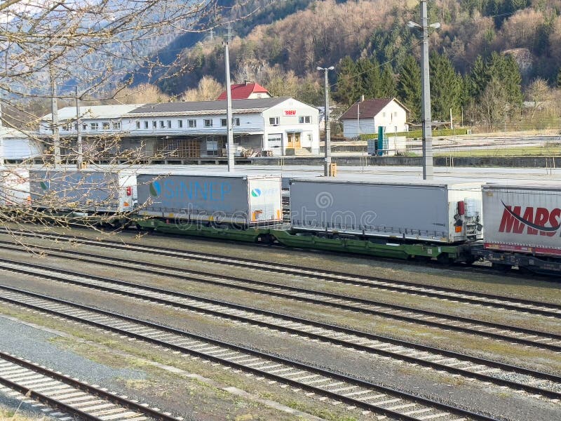 Cargo Train at Mountain Railway Station with Forest and Buildings in ...