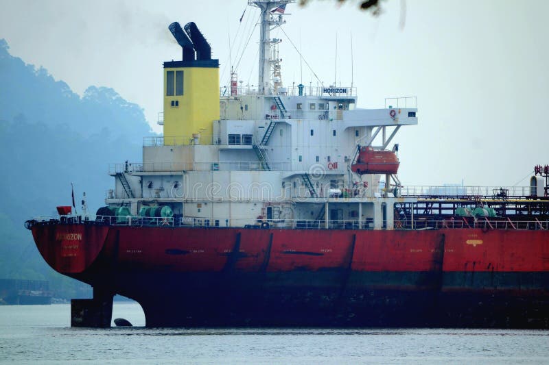 A Cargo Vessel Docked Near the Coastline, with Its Red Hull and White ...