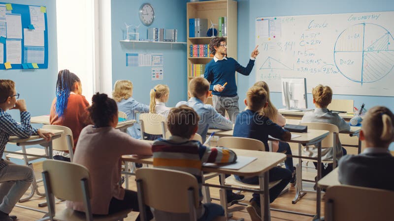 Caring Teacher Explains Lesson To a Classroom Full of Bright Diverse ...