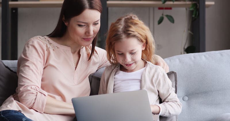 Caring Young Mum Showing Educational Application on Computer To ...
