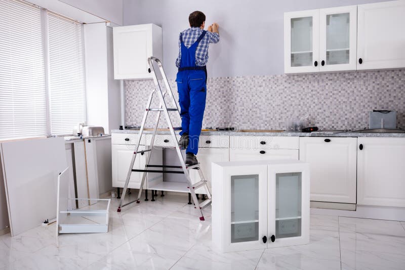 Carpenter Assembling Cabinet on Wall in Kitchen Stock Image - Image of ...