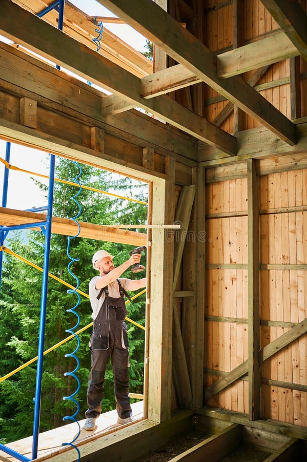 Carpenter Working with Screwdriver while Constructing Wooden Framed ...