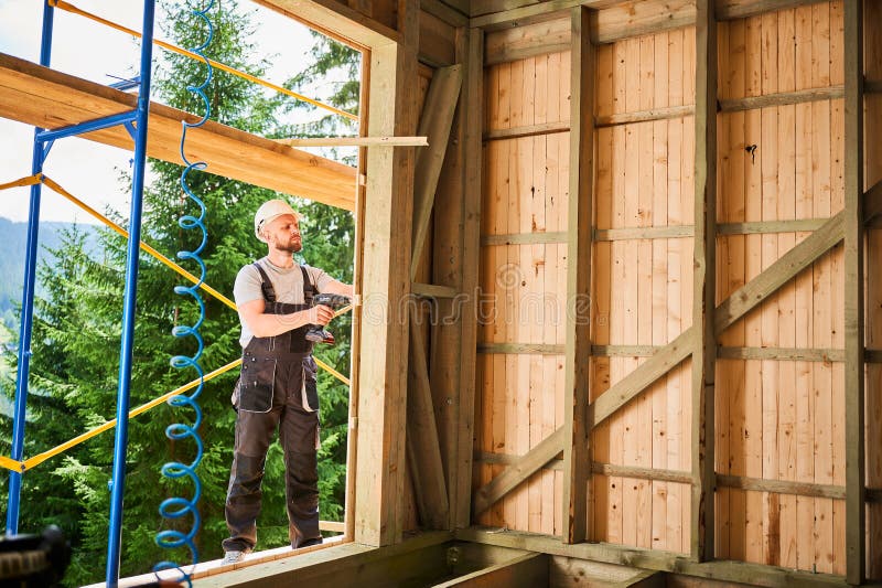 Carpenter Working with Screwdriver while Constructing Wooden Framed ...