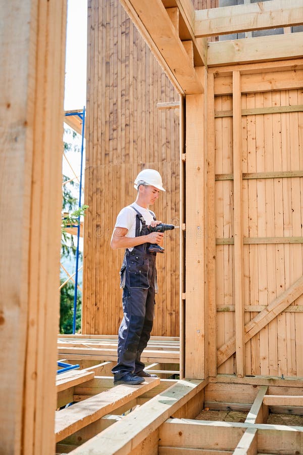 Carpenter Working with Screwdriver while Constructing Wooden Framed ...