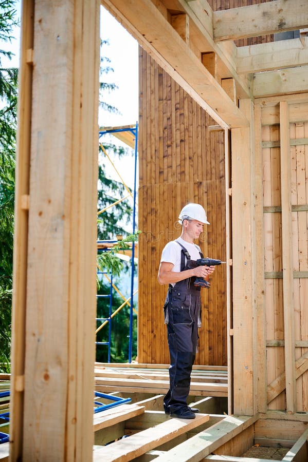 Carpenter Working with Screwdriver while Constructing Wooden Framed ...