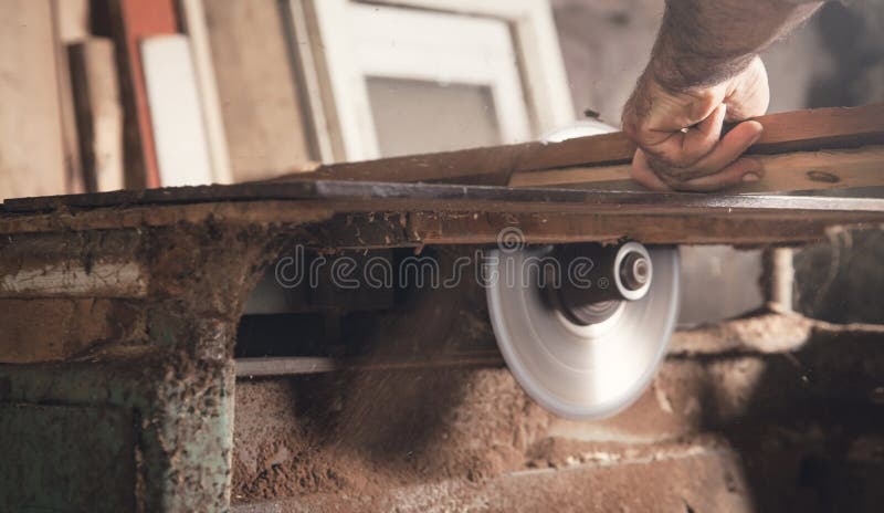 Carpenter Cutting a Piece of Wood with a Carpentry Machine Stock Photo ...