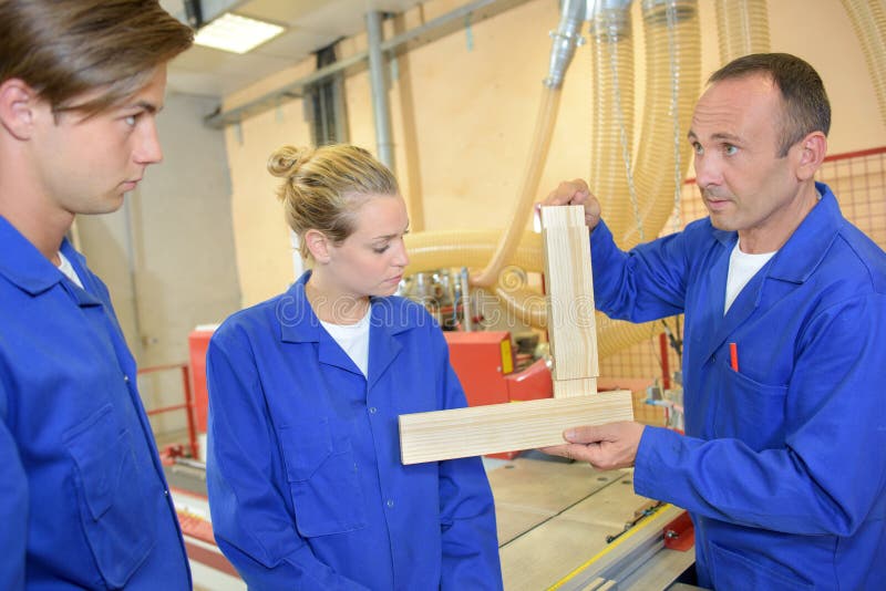 Carpenter Demonstrating To Two Apprentices Stock Photo - Image of ...