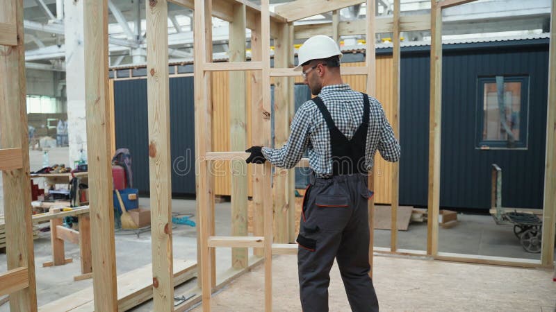 Carpenter in Uniform Installing Wooden Frame in Prefabricated Modular ...