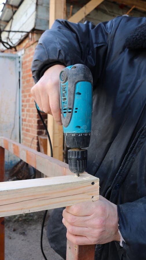 A Carpenter Fastens a Structure Made of Bars with a Self-tapping Stock ...