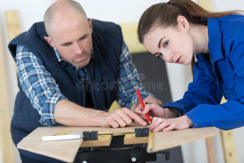 Carpenter with Female Apprentice Working on Building Site Stock Photo ...