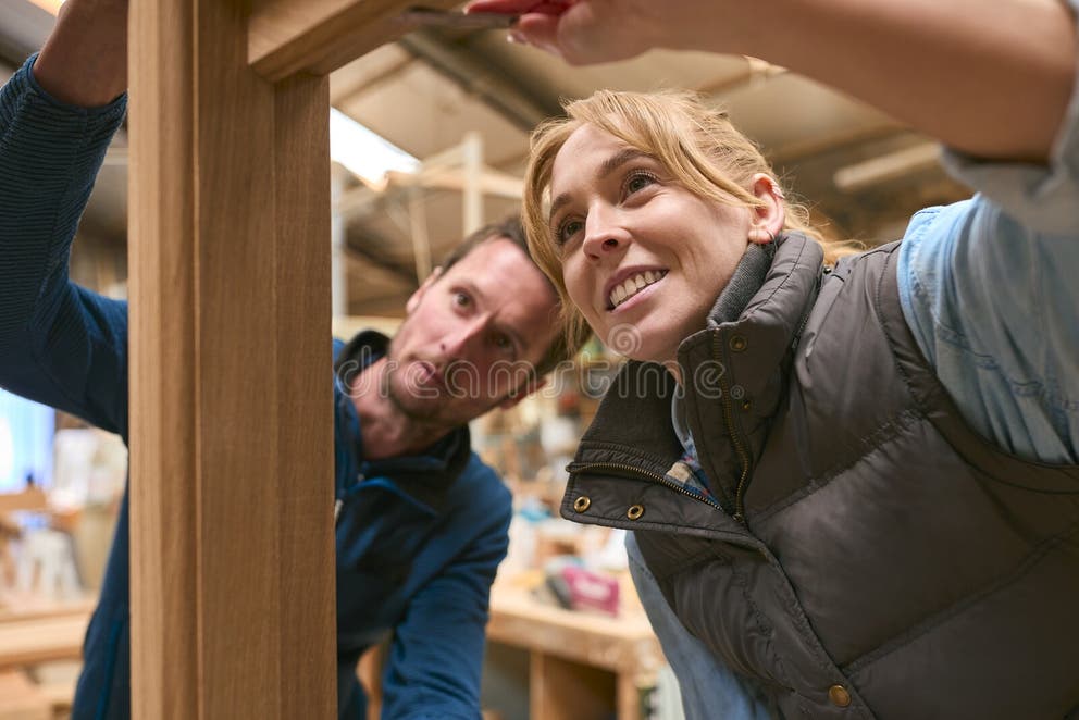 Carpenter with Female Apprentice in Workshop Using Ruler To Measure ...