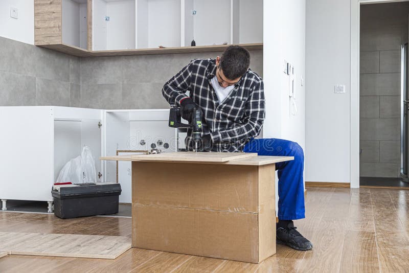 The Carpenter Finalizing the Assembly of the Kitchen Shelf Stock Image ...