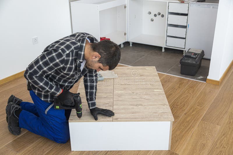 The Carpenter Finalizing the Assembly of the Kitchen Shelf Stock Photo ...