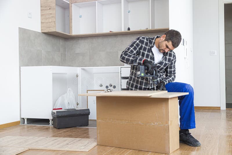 The Carpenter Finalizing the Assembly of the Kitchen Shelf Stock Photo ...