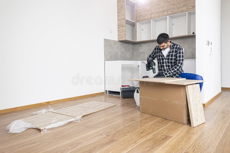 The Carpenter Finalizing the Assembly of the Kitchen Shelf Stock Photo ...