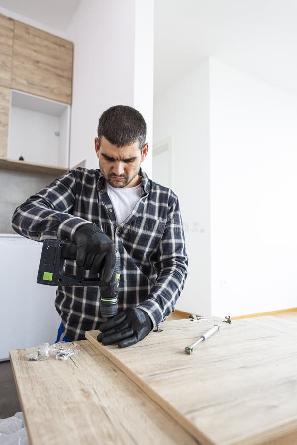 The Carpenter Finalizing the Assembly of the Kitchen Shelf Stock Image ...
