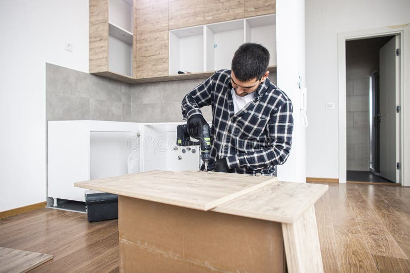 The Carpenter Finalizing the Assembly of the Kitchen Shelf Stock Photo ...