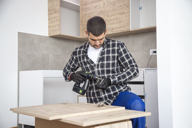 The Carpenter Finalizing the Assembly of the Kitchen Shelf Stock Image ...