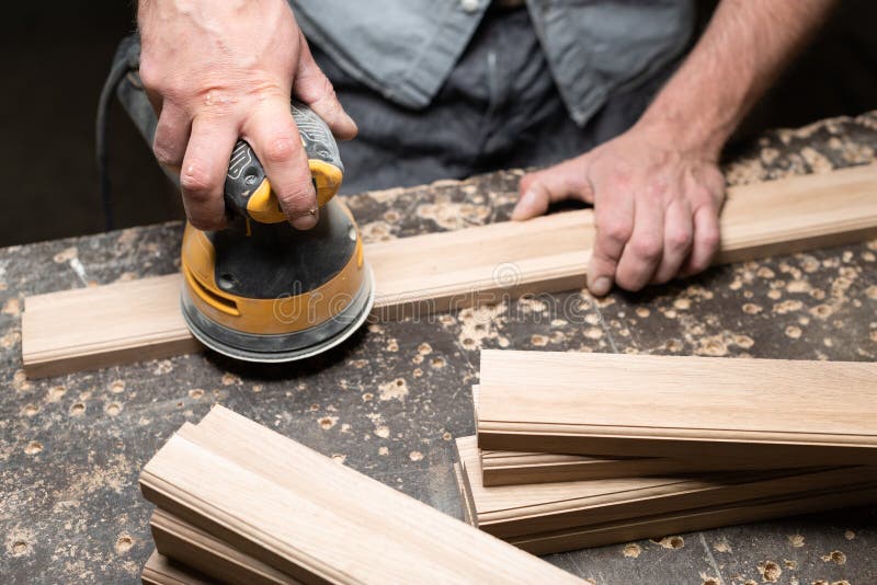 A Carpenter Grinds an Oak Plank Part with a Hand Grinder Stock Photo ...