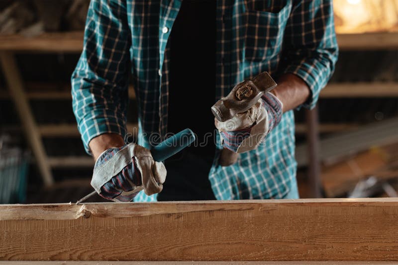 Carpenter with a Hammer and Chisel Handles Wood. Joiner at Work in the ...