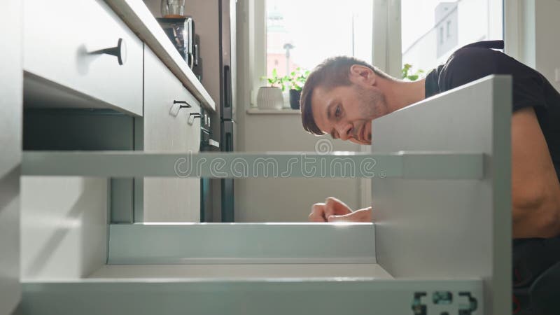 Carpenter Installing and Adjusting Drawer Front in Modern Kitchen ...