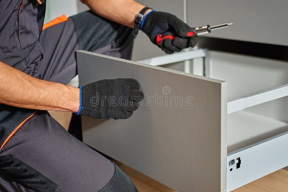 Carpenter Installing and Adjusting Drawer Front in Modern Kitchen ...