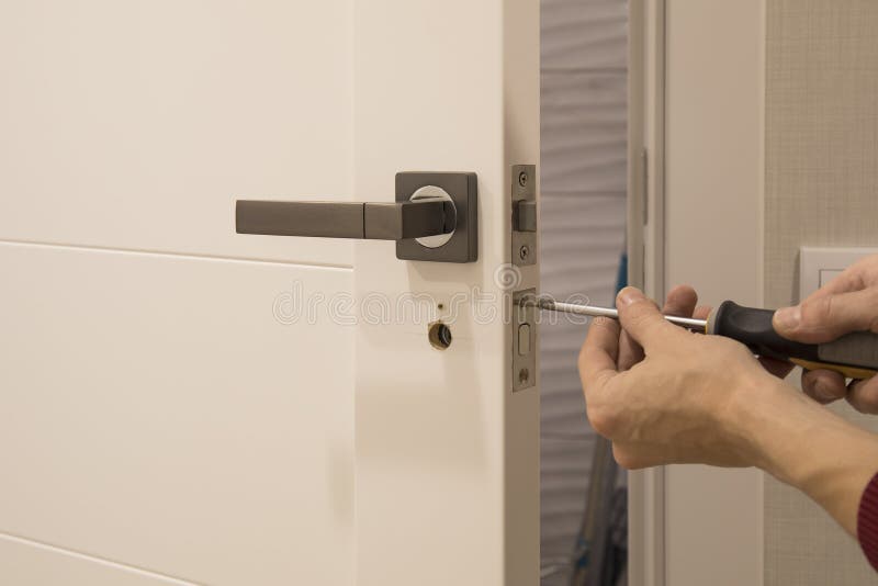 Carpenter Installing the Lock on the Door Installation of the Door Lock ...
