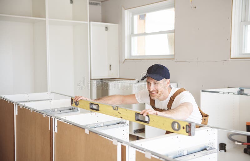 Carpenter Installing Luxury Modern Fitted Kitchen in House Stock Photo ...
