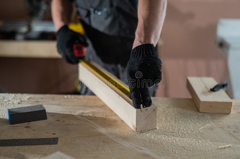 Carpenter Measures Wooden Planks in the Workshop. Stock Photo - Image ...