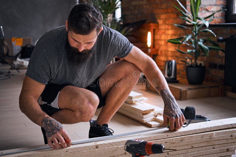Carpenter Measuring Boards in a Room with Loft Interior. Stock Photo ...