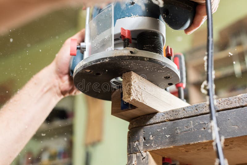 A Carpenter is Milling an Oak Part with a Hand-held Milling Cutter in ...