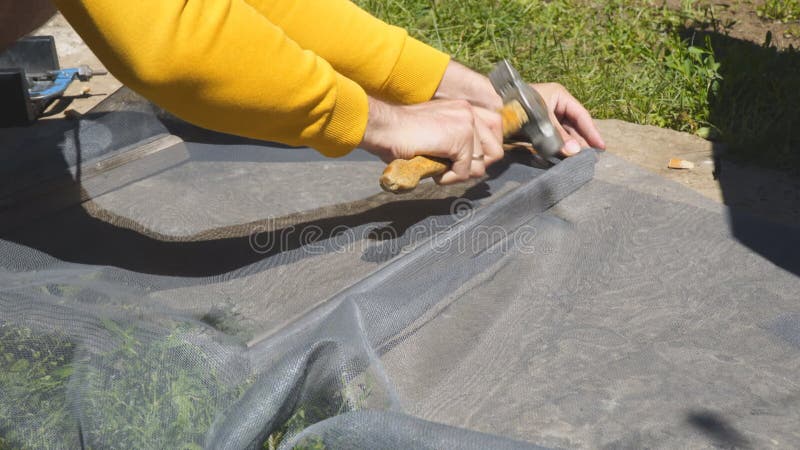 Carpenter Nails a Mosquito Net on the Window Stock Footage - Video of ...