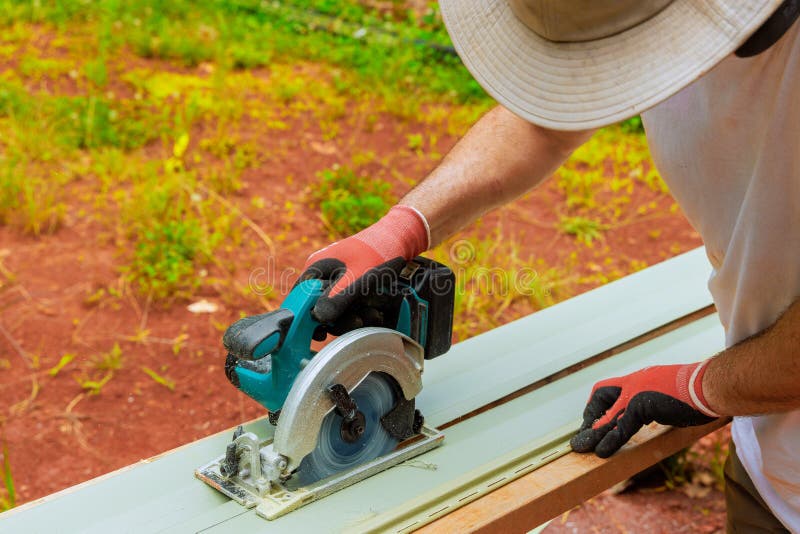 Worker Uses Power Saw To Cut Vinyl Siding for Construction Project ...