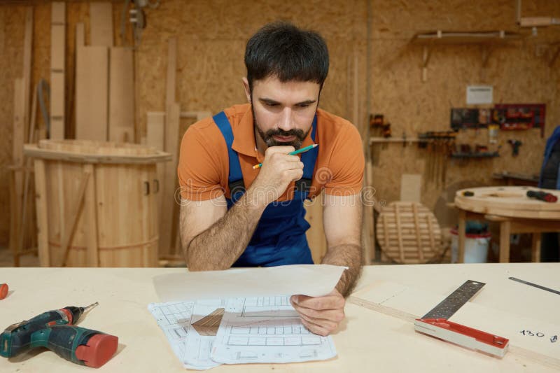 Carpenter Reading Blueprints and Thinking during Woodworking Process ...