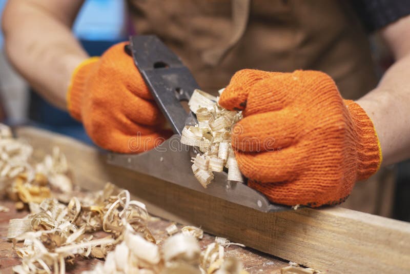 Carpenter`s Hands Planing a Plank of Wood with a Hand Plane, Workplace ...