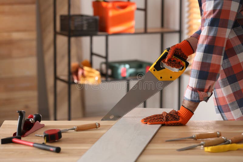 Carpenter Sawing Wooden Plank at Table in Workshop, Closeup. Space for ...
