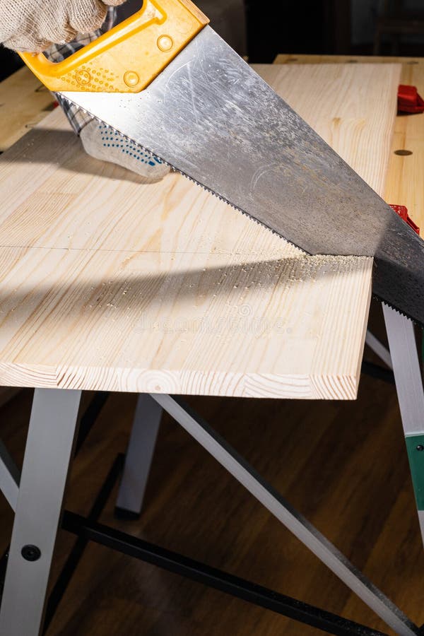 Carpenter Saws Wooden Board with Hand Saw at Home Stock Photo - Image ...