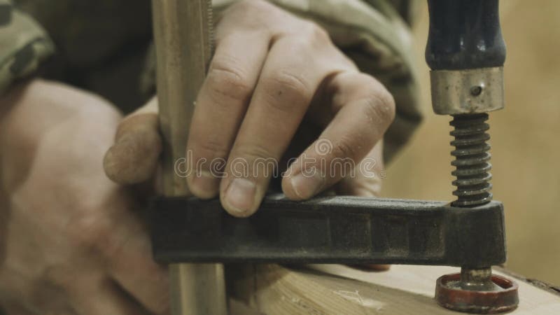 A Carpenter Secures a Piece of Wood Using a Clamp. Stock Footage ...