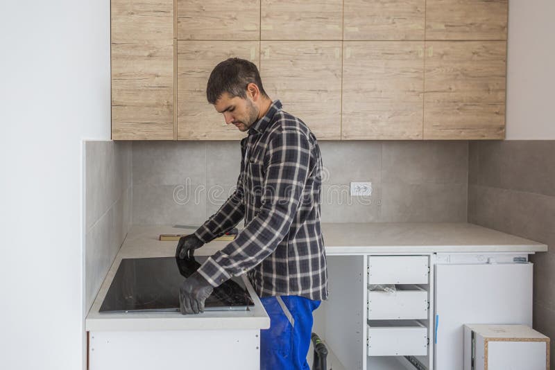 The Carpenter Sets Up the Induction Hob in New Kitchen Stock Photo ...