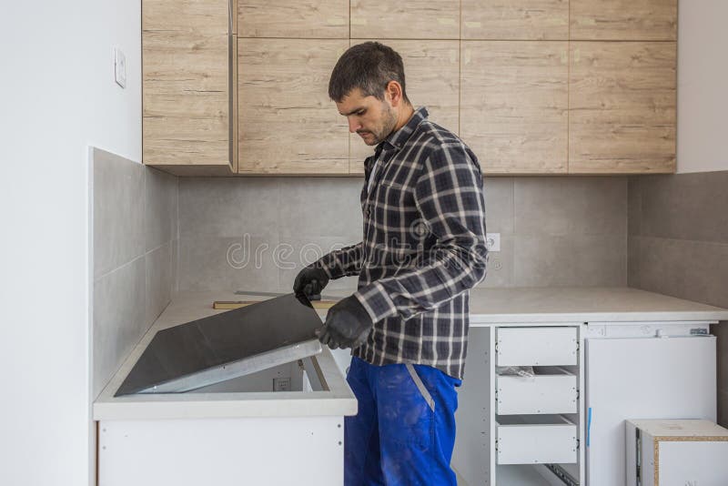 The Carpenter Sets Up the Induction Hob in New Kitchen Stock Image ...