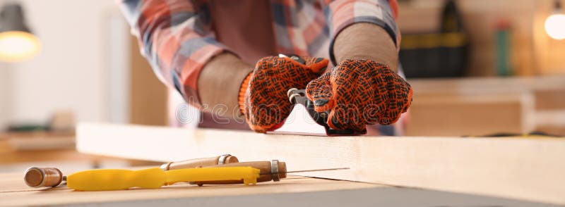 Carpenter Shaping Wooden Bar with Plane at Table in Workshop, Focus on ...