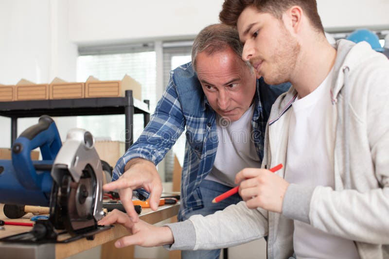 Carpenter Showing Apprentice How To Use Sawing Machine Stock Image ...