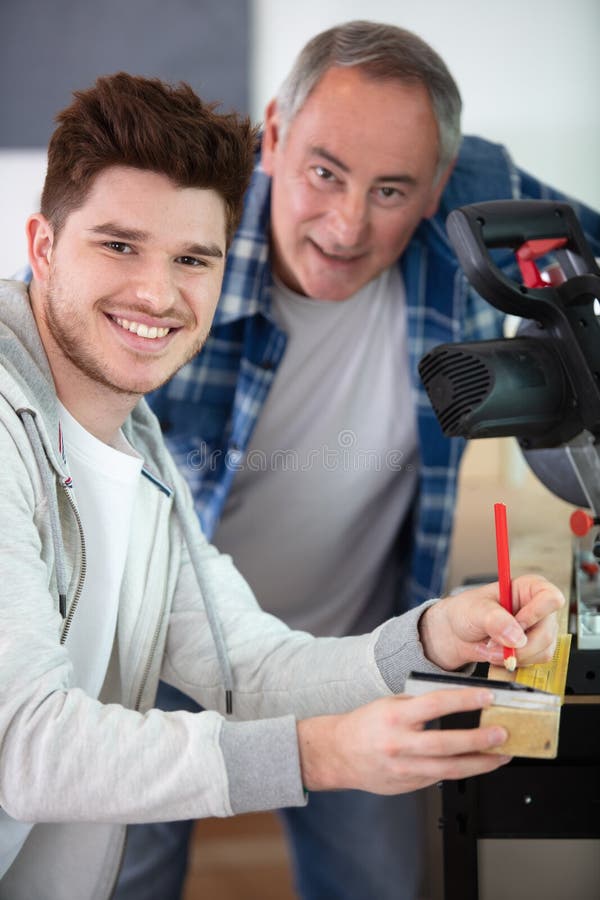Carpenter Teaching Apprentice How To Cut Wood Stock Image - Image of ...