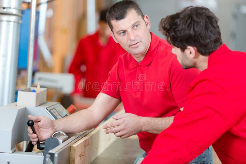 Carpenter Training Male Apprentice To Use Machinery Stock Image - Image ...