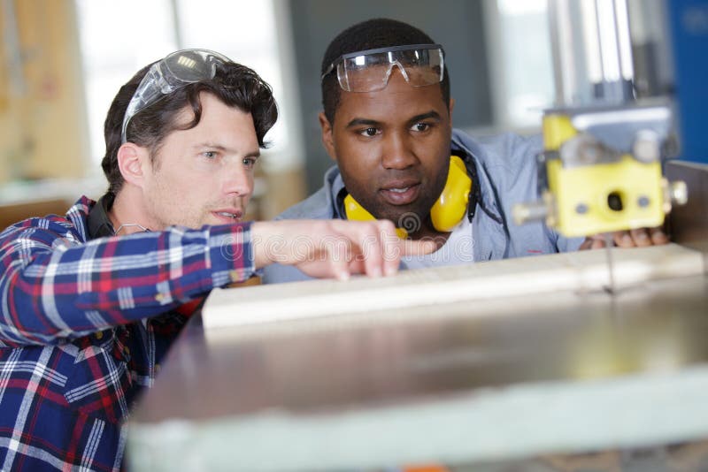 Carpenter Training Male Apprentice To Use Mechanized Saw Stock Photo ...