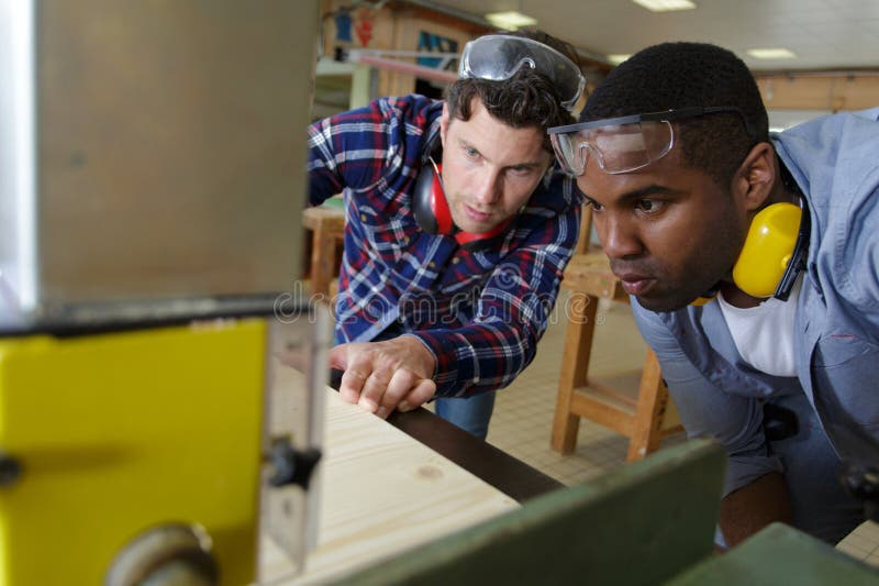 Carpenter Training Male Apprentice To Use Mechanized Saw Stock Image ...